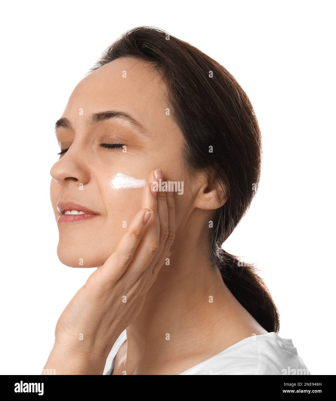 Woman applying facial cream on white background Stock Photo - Alamy