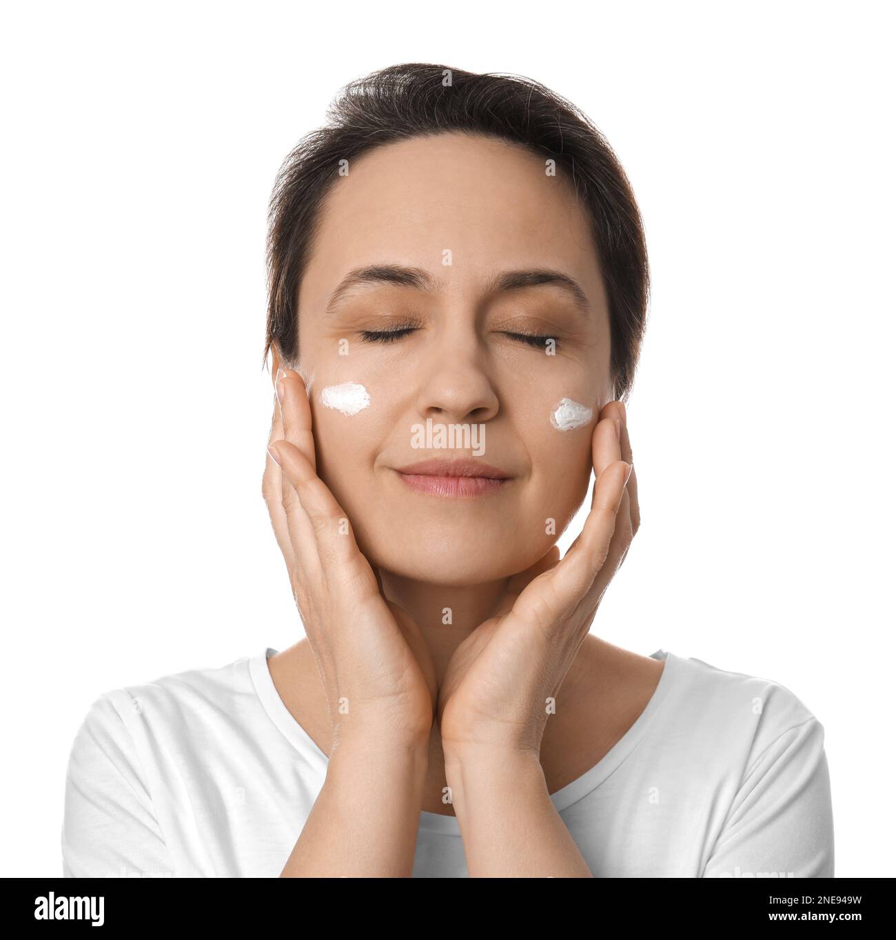 Woman applying facial cream on white background Stock Photo - Alamy