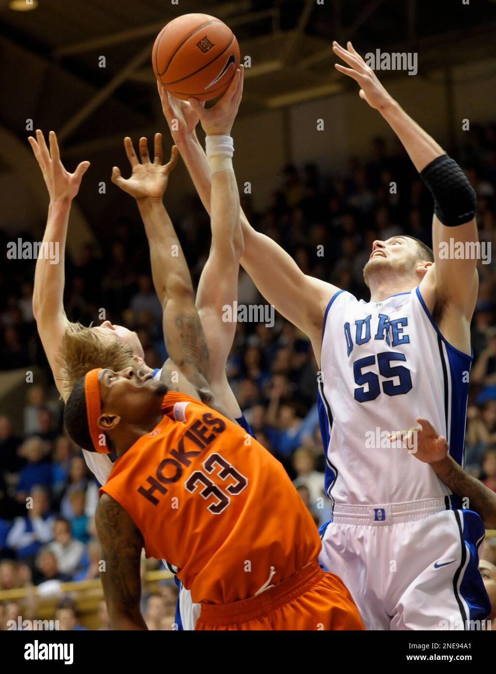 Duke's Brian Zoubek (55) and Kyle Singler, back, reach for a rebound ...