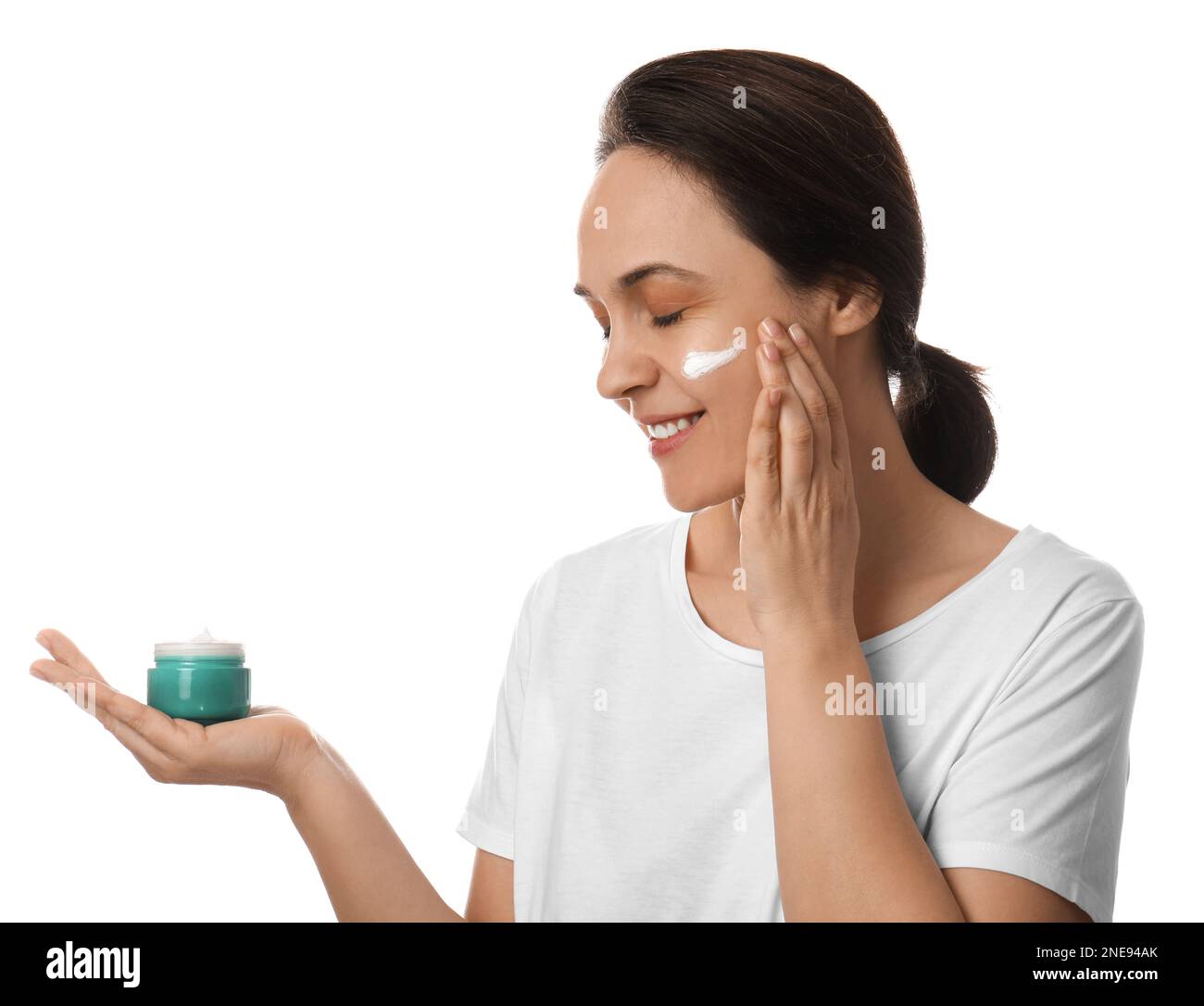 Woman applying facial cream on white background Stock Photo - Alamy