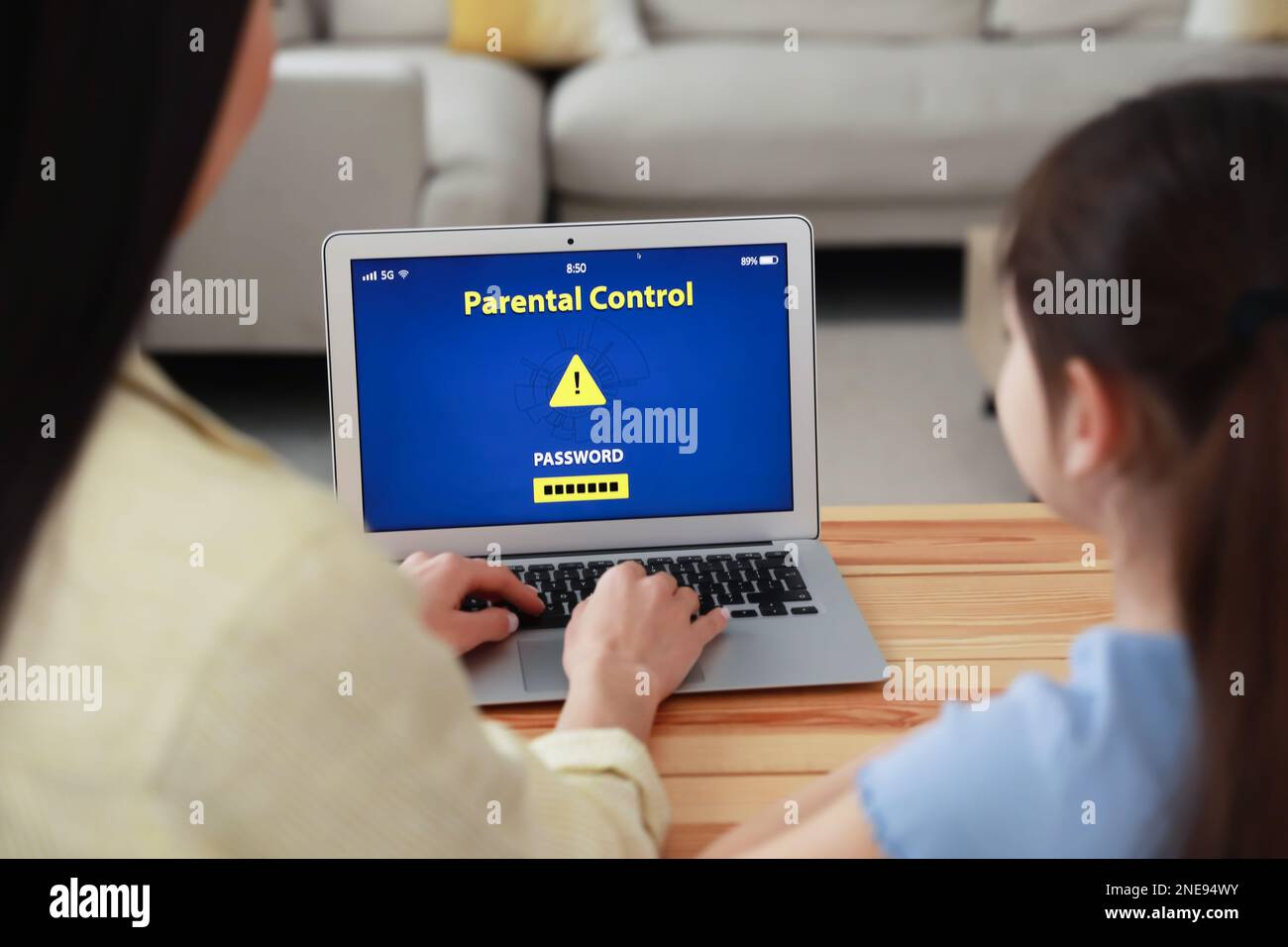 Mother installing parental control app on laptop to ensure her child's ...