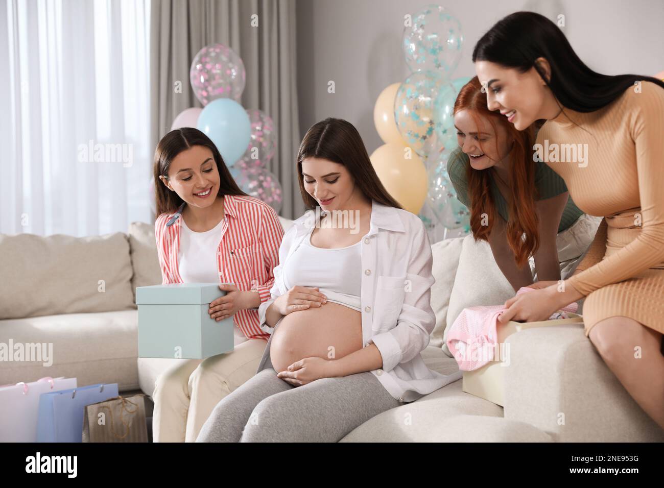 Happy pregnant woman spending time with friends at baby shower party ...