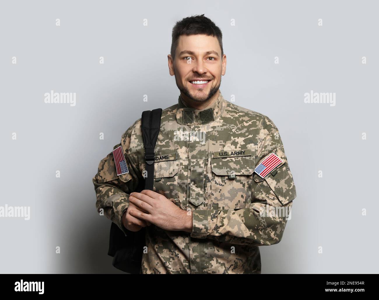 Cadet with backpack on light grey background. Military education Stock ...