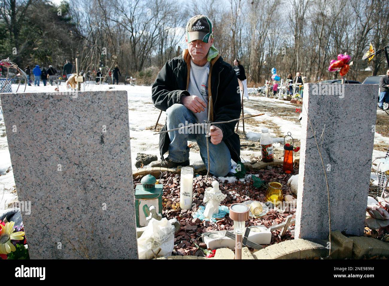 Kevin Lackey, from Warwick, R.I., places a cross at a memorial for his ...