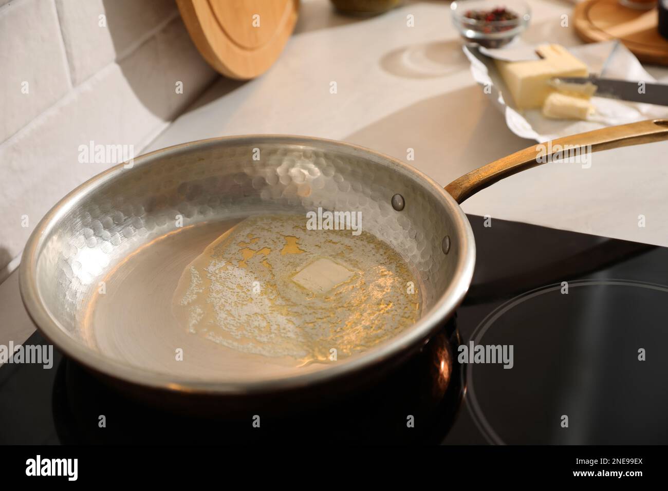 Frying pan with melted butter on stove, closeup Stock Photo - Alamy