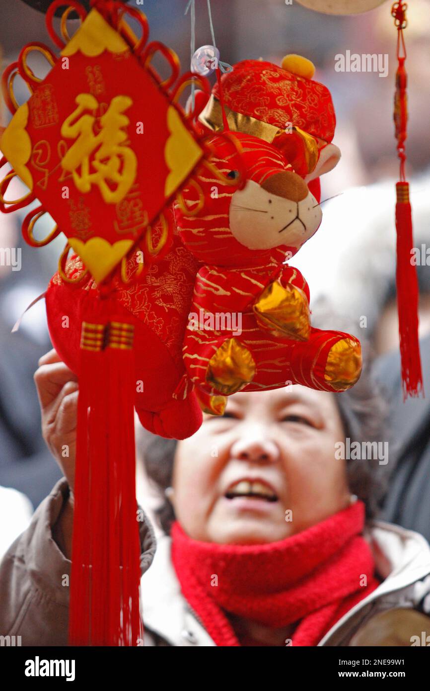 A woman looks at tiger toy for sale at a stall in China Town, London ...