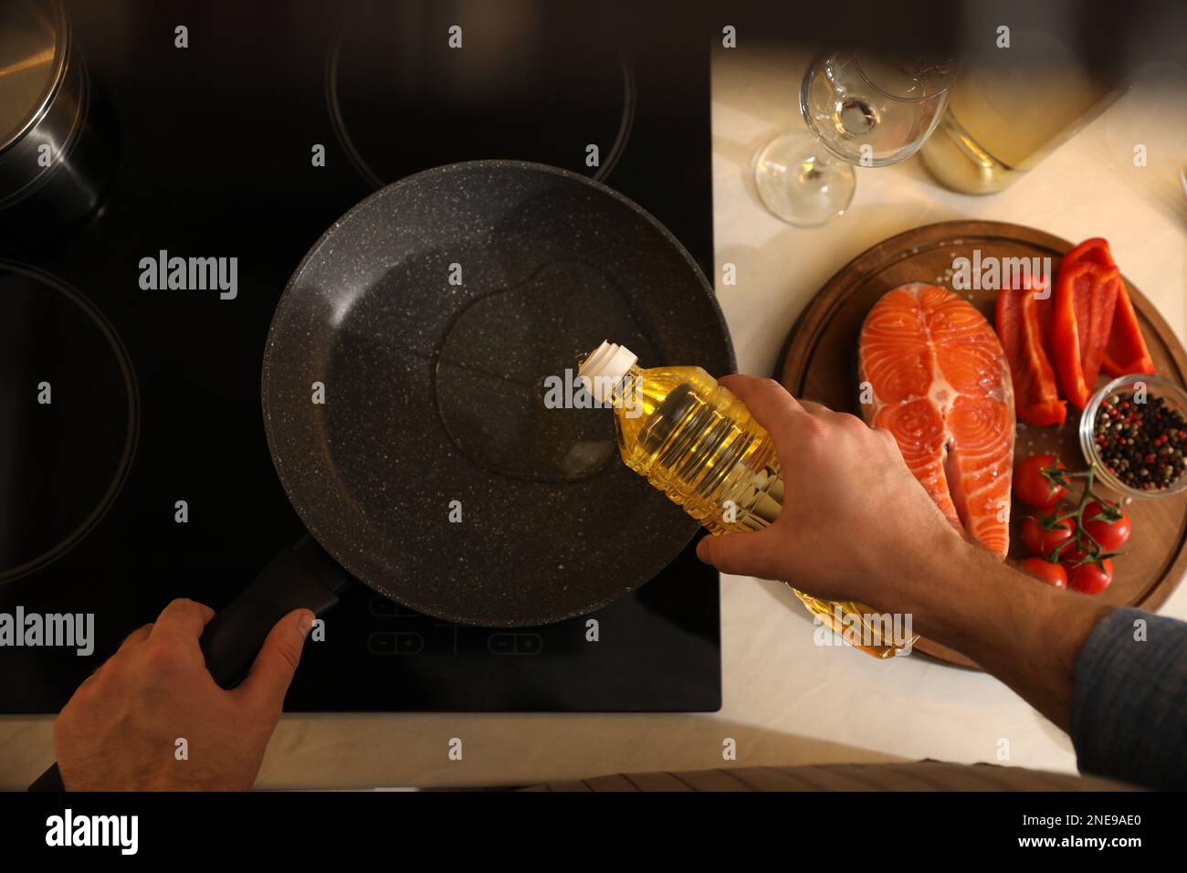 Man pouring cooking oil into frying pan, top view Stock Photo - Alamy