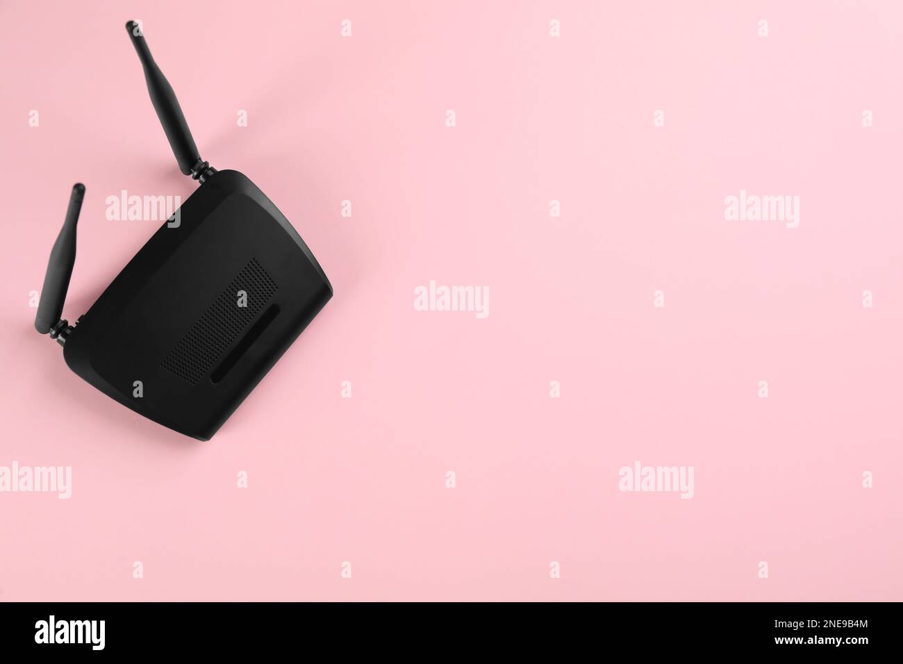 Modern Wi-Fi router on light pink background, top view. Space for text ...