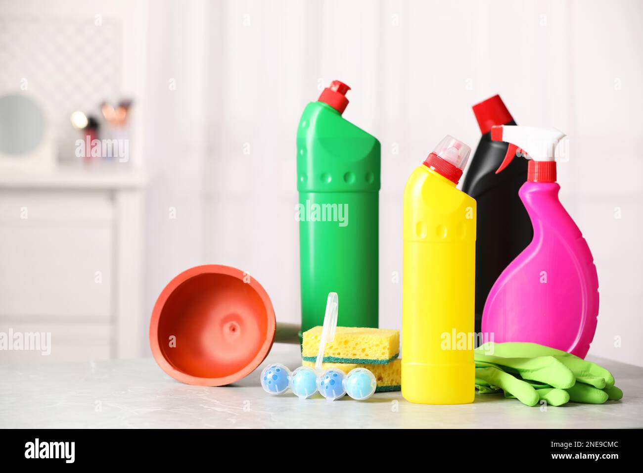 Different toilet cleaning supplies and tools on light grey table ...