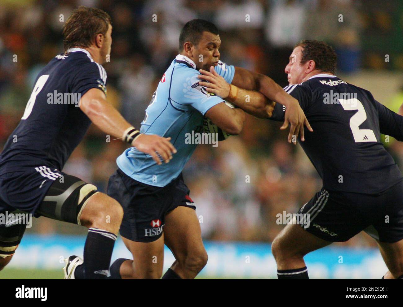 Kurtley Beale of Australia's Waratahs, center, is tackled by Duane ...