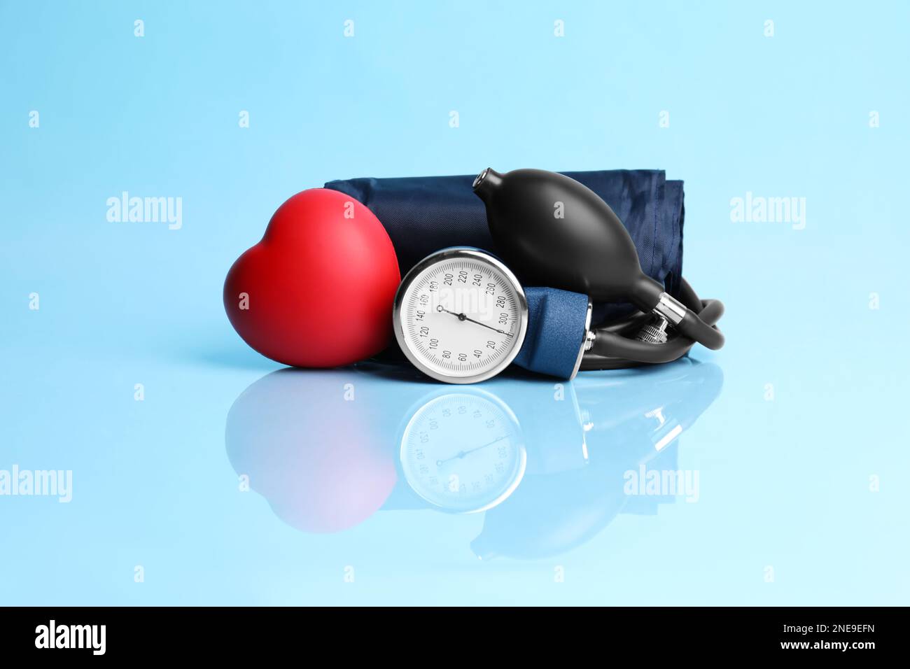 Blood pressure meter and toy heart on light blue background Stock Photo ...