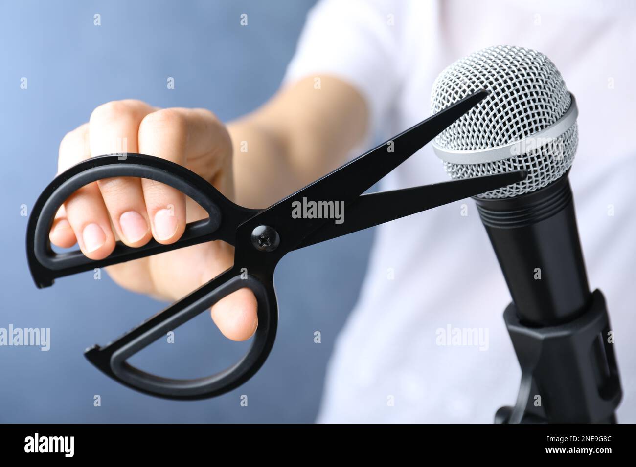 Woman making ASMR sounds with microphone and scissors on blue ...