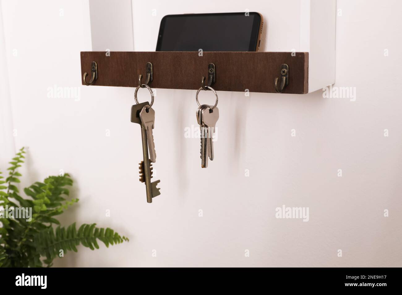 Wooden hanger for keys on white wall Stock Photo - Alamy