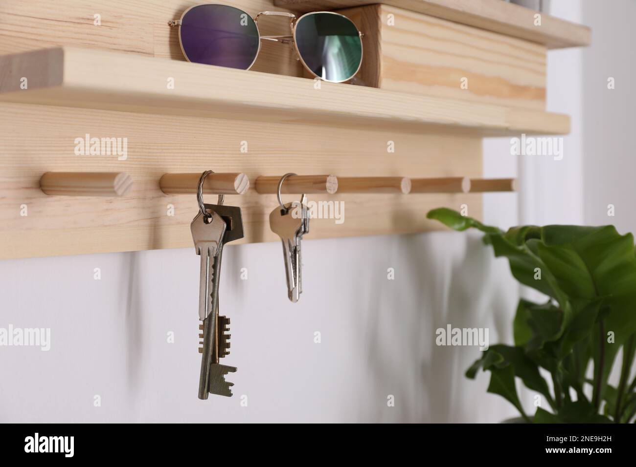 Wooden hanger for keys on white wall, closeup Stock Photo - Alamy