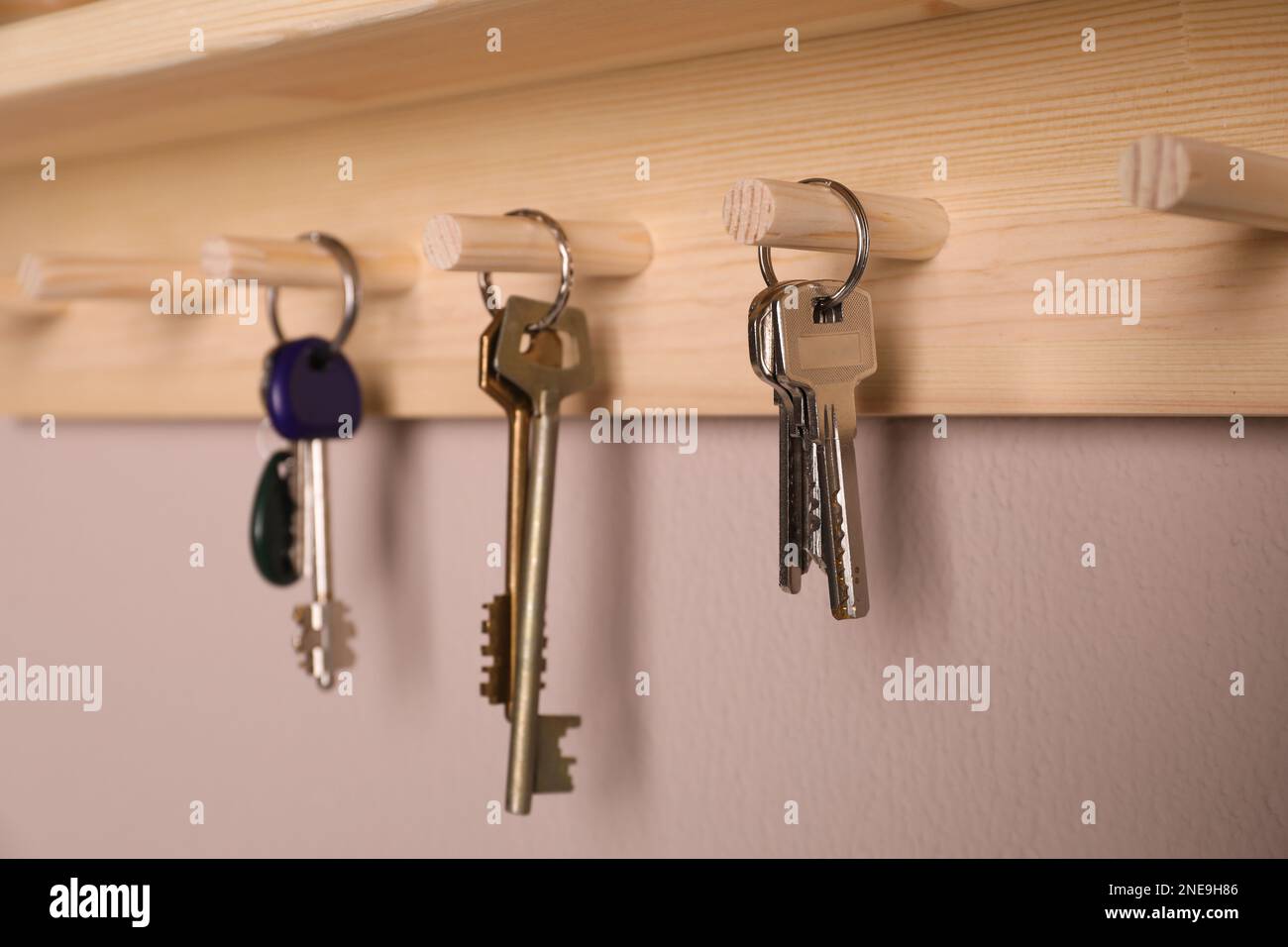 Wooden hanger for keys on color wall, closeup Stock Photo - Alamy