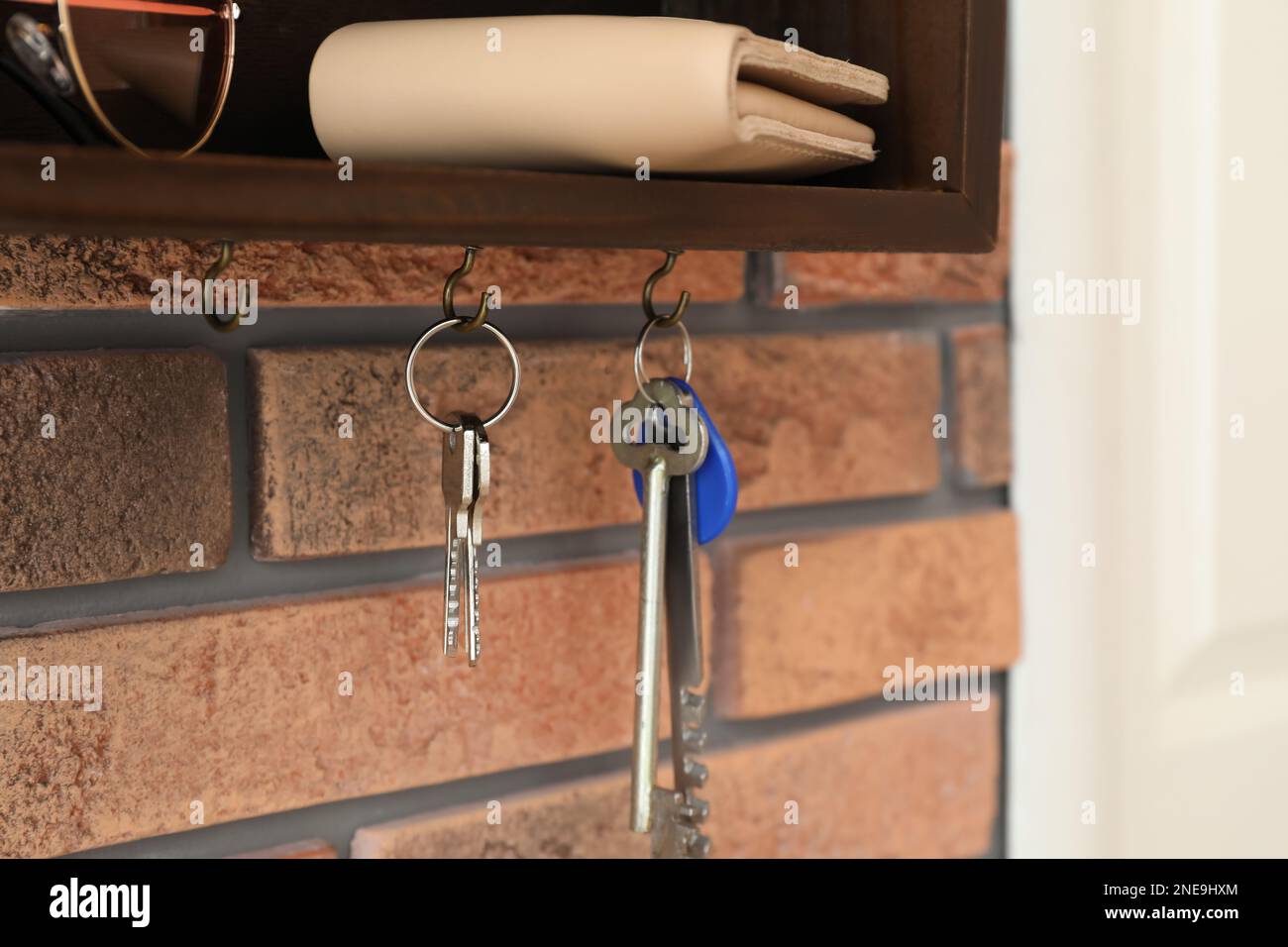 Hanger for keys with accessories on brick wall Stock Photo - Alamy