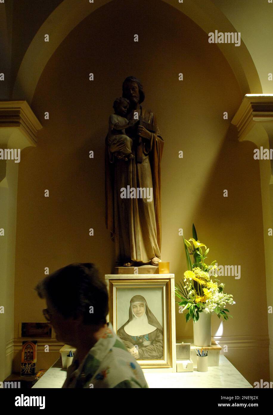 A woman passes an image of Australia's first Catholic saint Mary ...