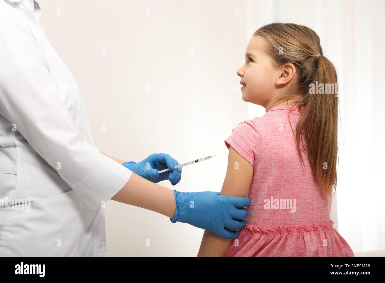 Doctor giving injection to little girl in hospital. Immunization ...