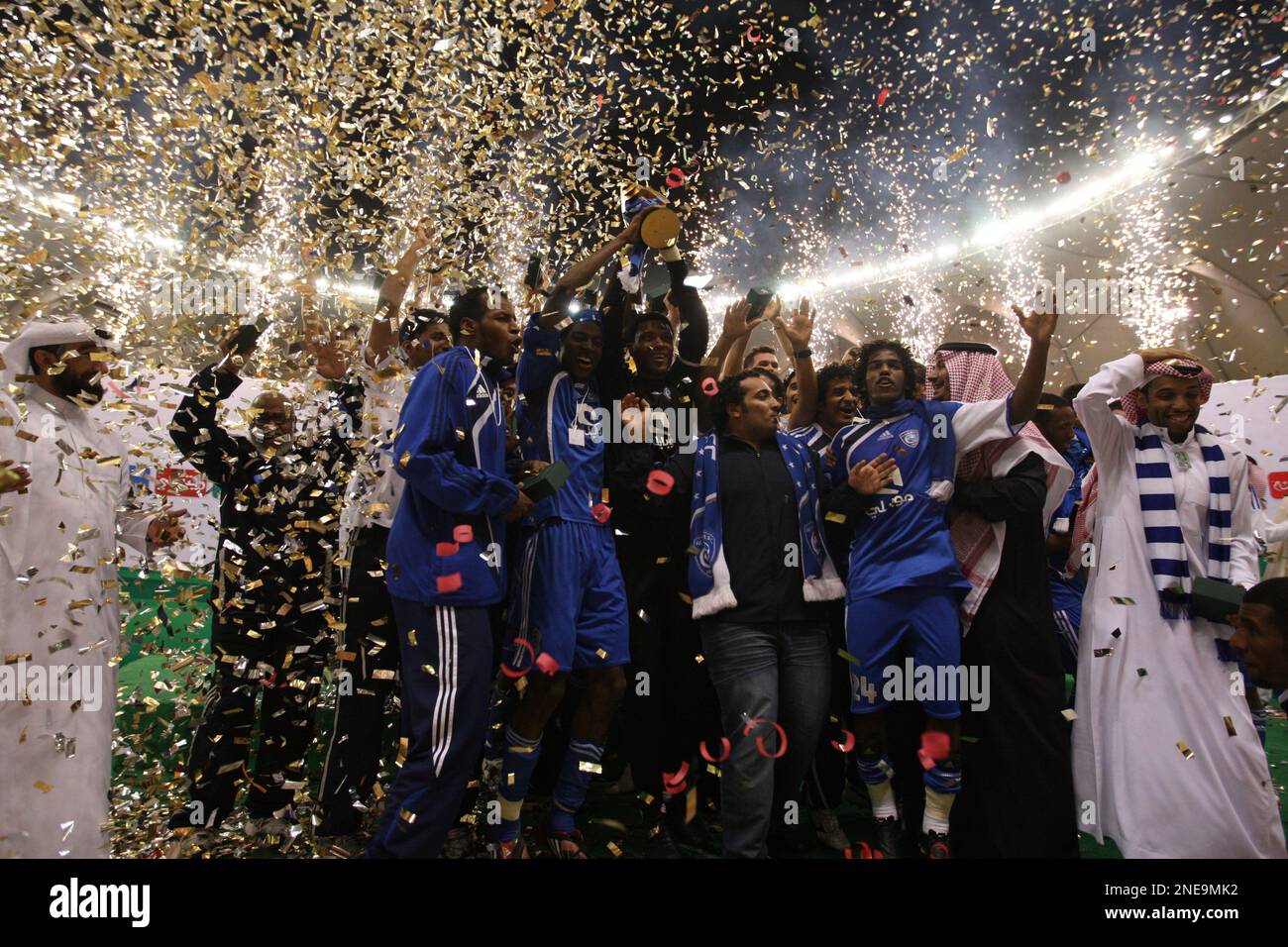 Al Hilal's captain Mohamed Al-Deayea holds up the trophy as he and ...