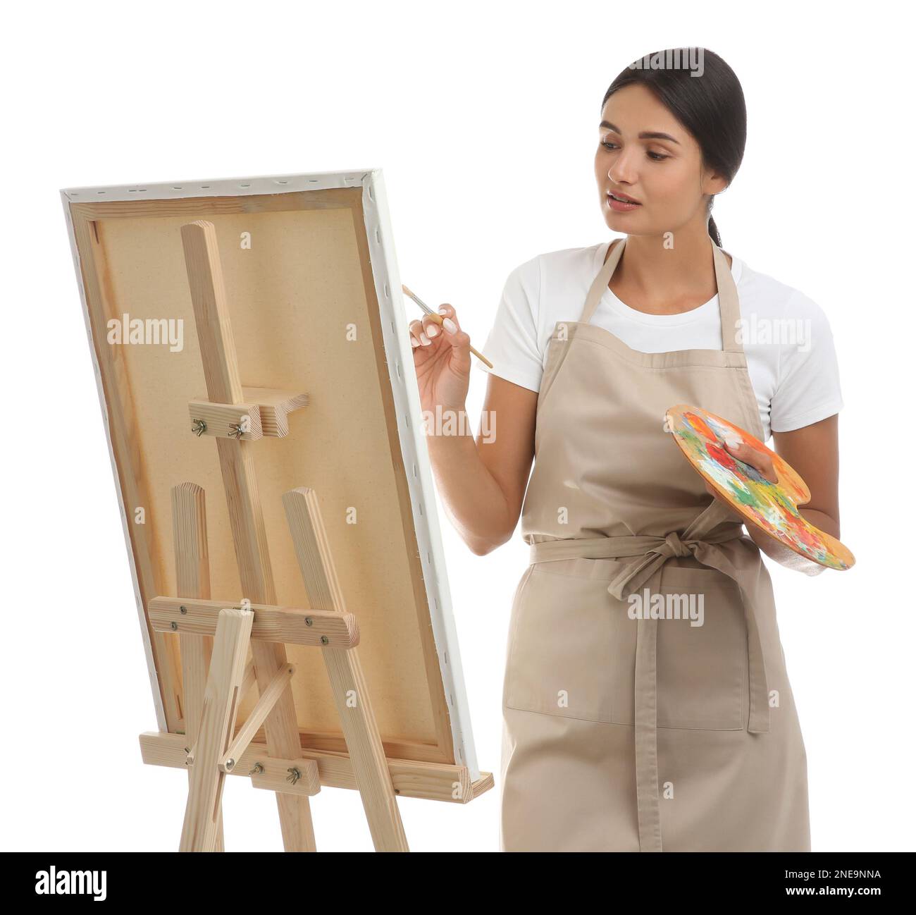 Young woman drawing on easel against white background Stock Photo - Alamy