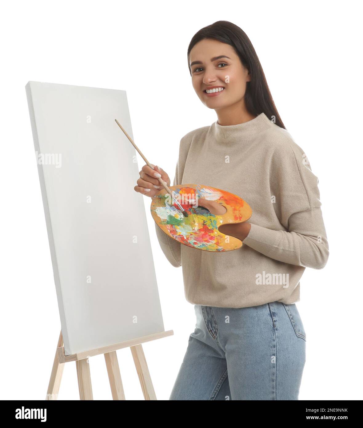 Young woman drawing on easel against white background Stock Photo - Alamy
