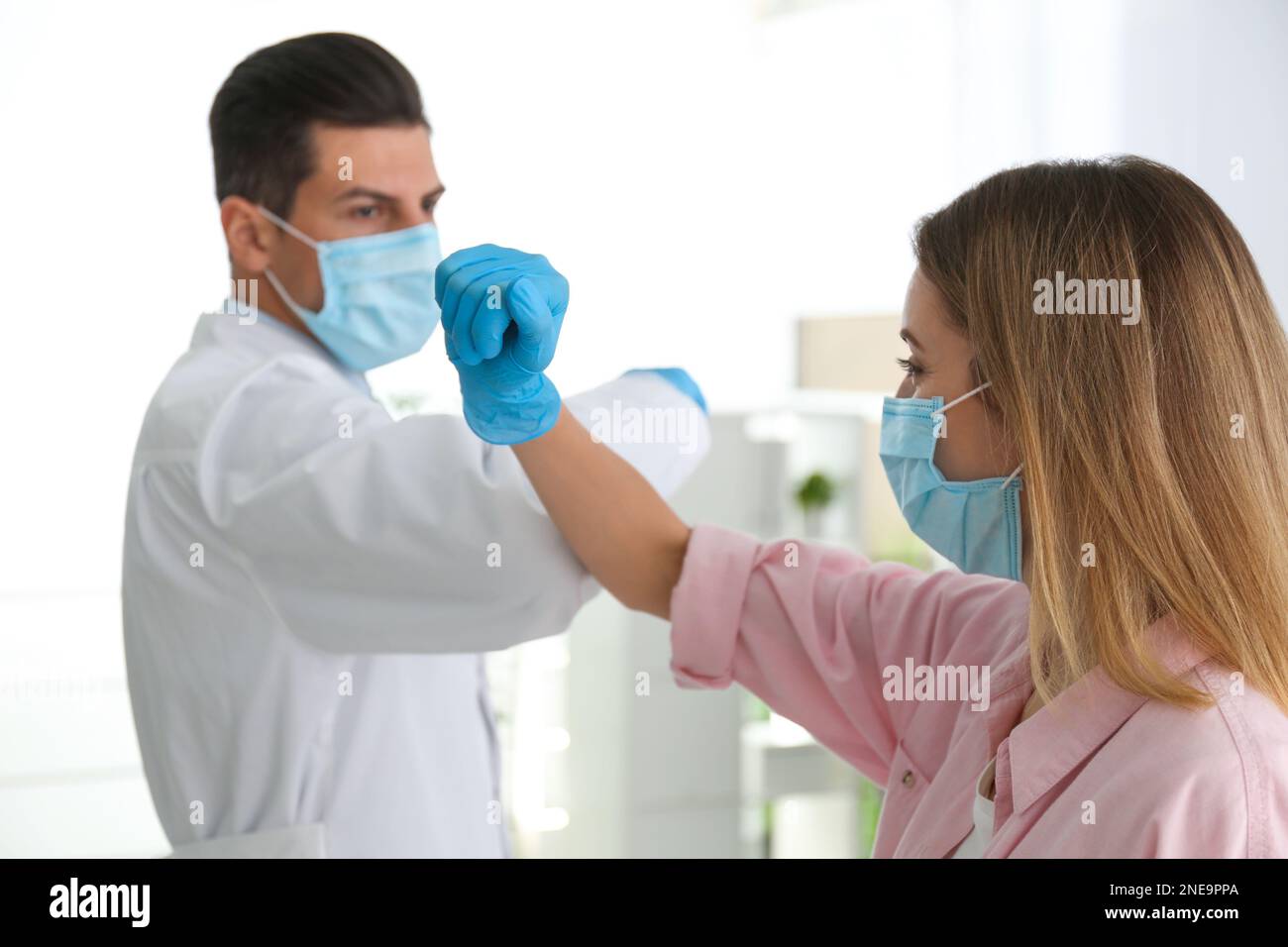 Doctor and patient doing elbow bump instead of handshake in clinic. New ...