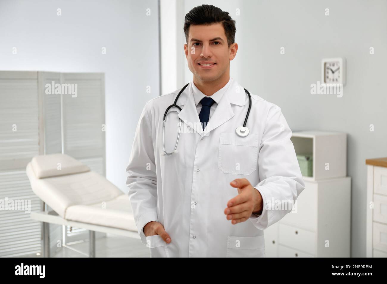 Happy male doctor offering handshake in clinic Stock Photo - Alamy