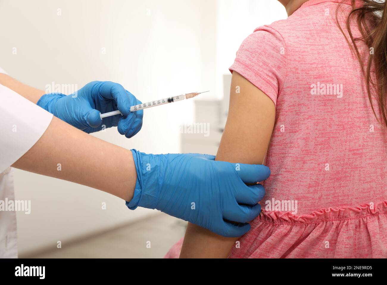 Doctor giving injection to little girl in hospital, closeup ...