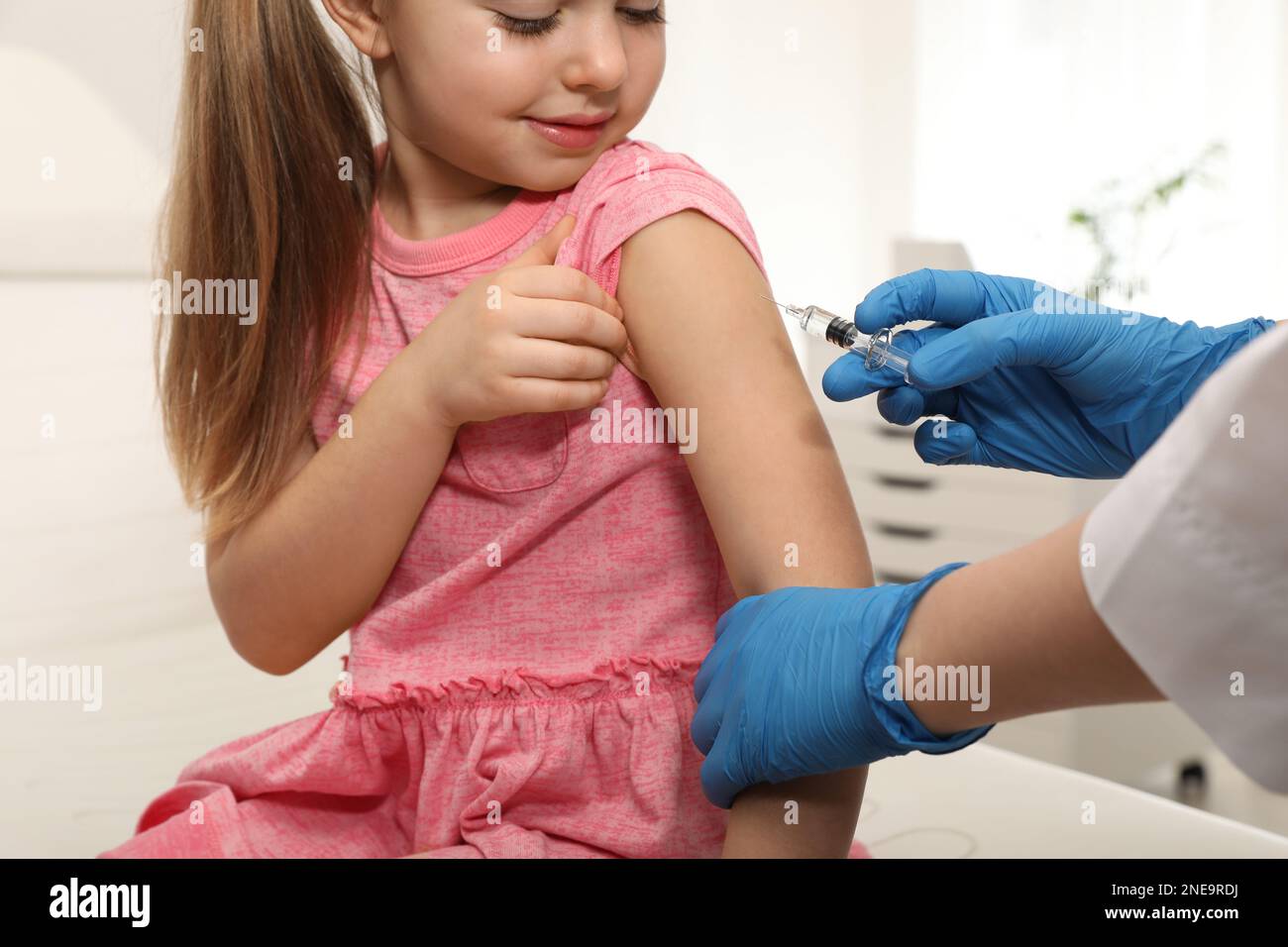 Doctor giving injection to little girl in hospital. Immunization ...
