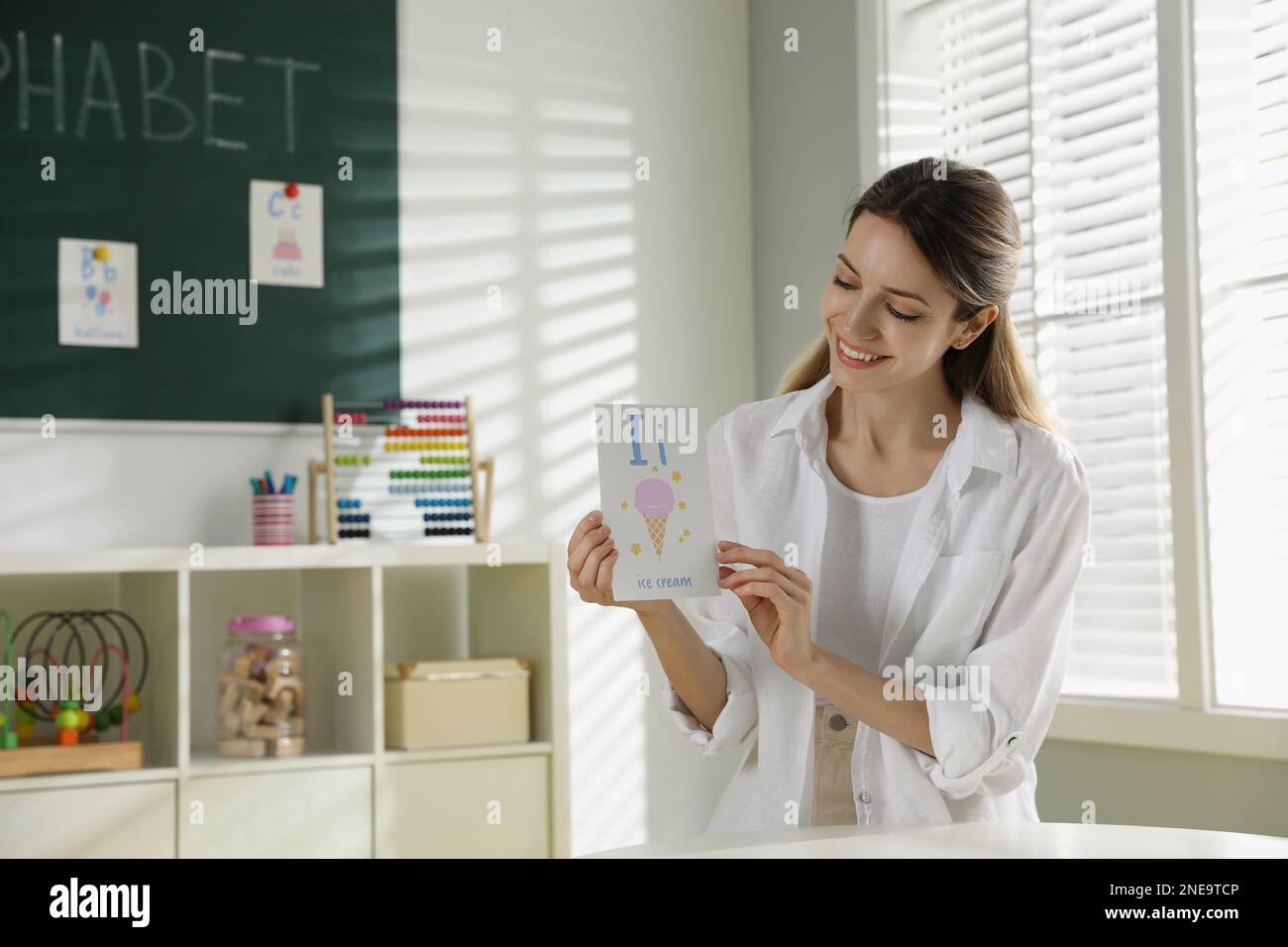 Happy female English teacher giving lesson in elementary school Stock ...