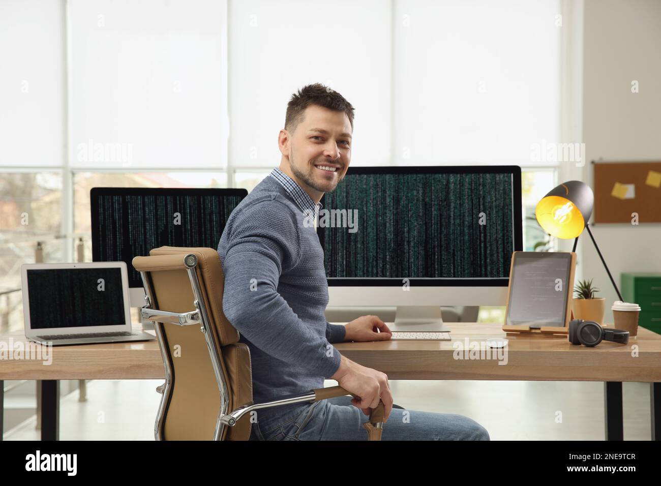 Happy programmer working at desk in office Stock Photo - Alamy