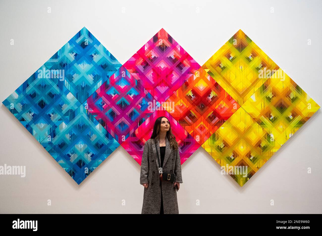 London, UK. 16 February 2023. A staff member with works by Maya Hayuk ...