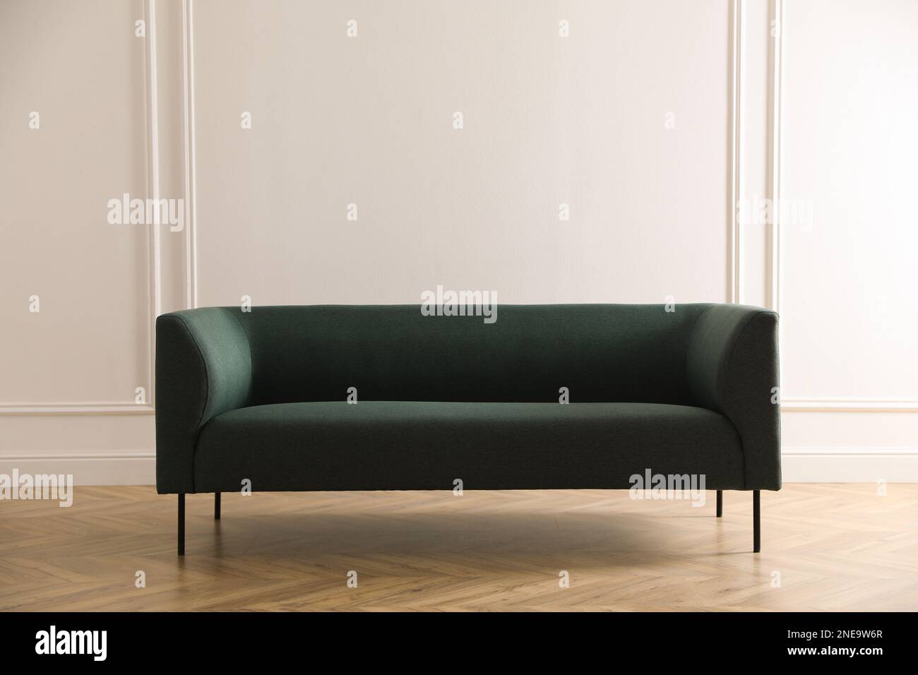 Comfortable green sofa near white wall indoors. Interior design Stock ...