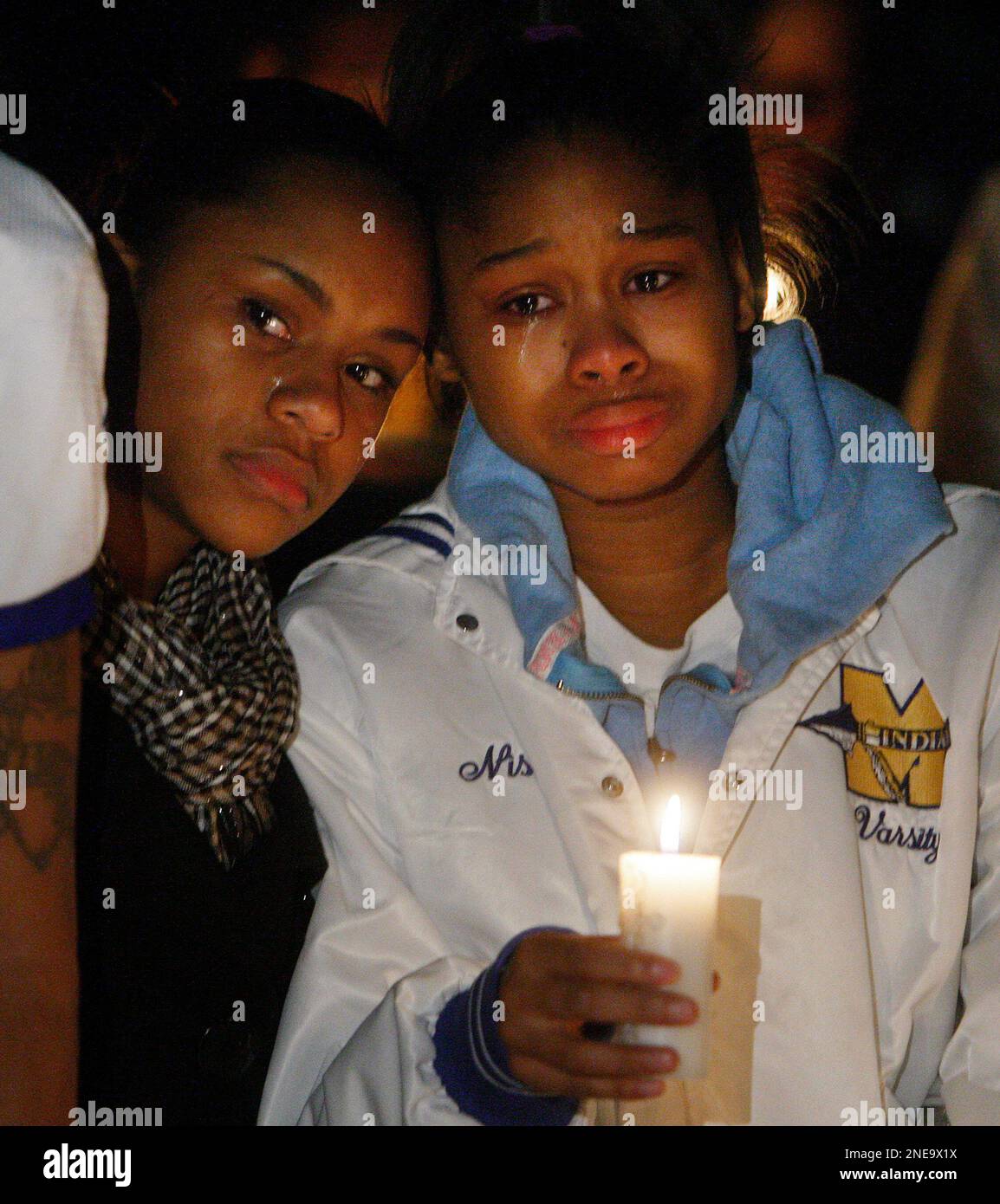 Mourners huddle together during a candlelight vigil for McEachern High ...