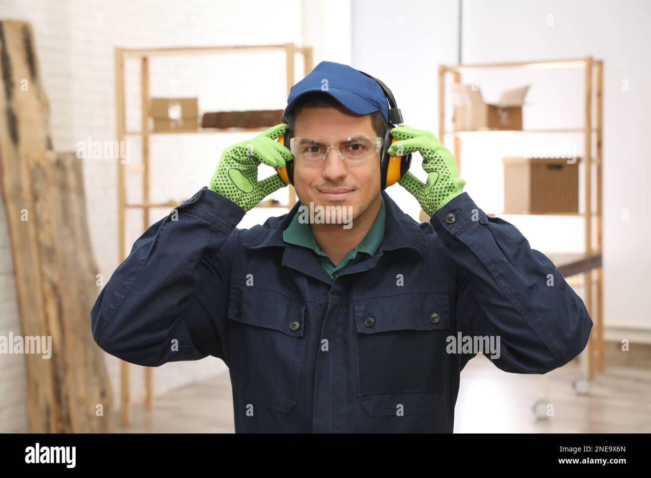 Worker wearing safety headphones indoors. Hearing protection device ...