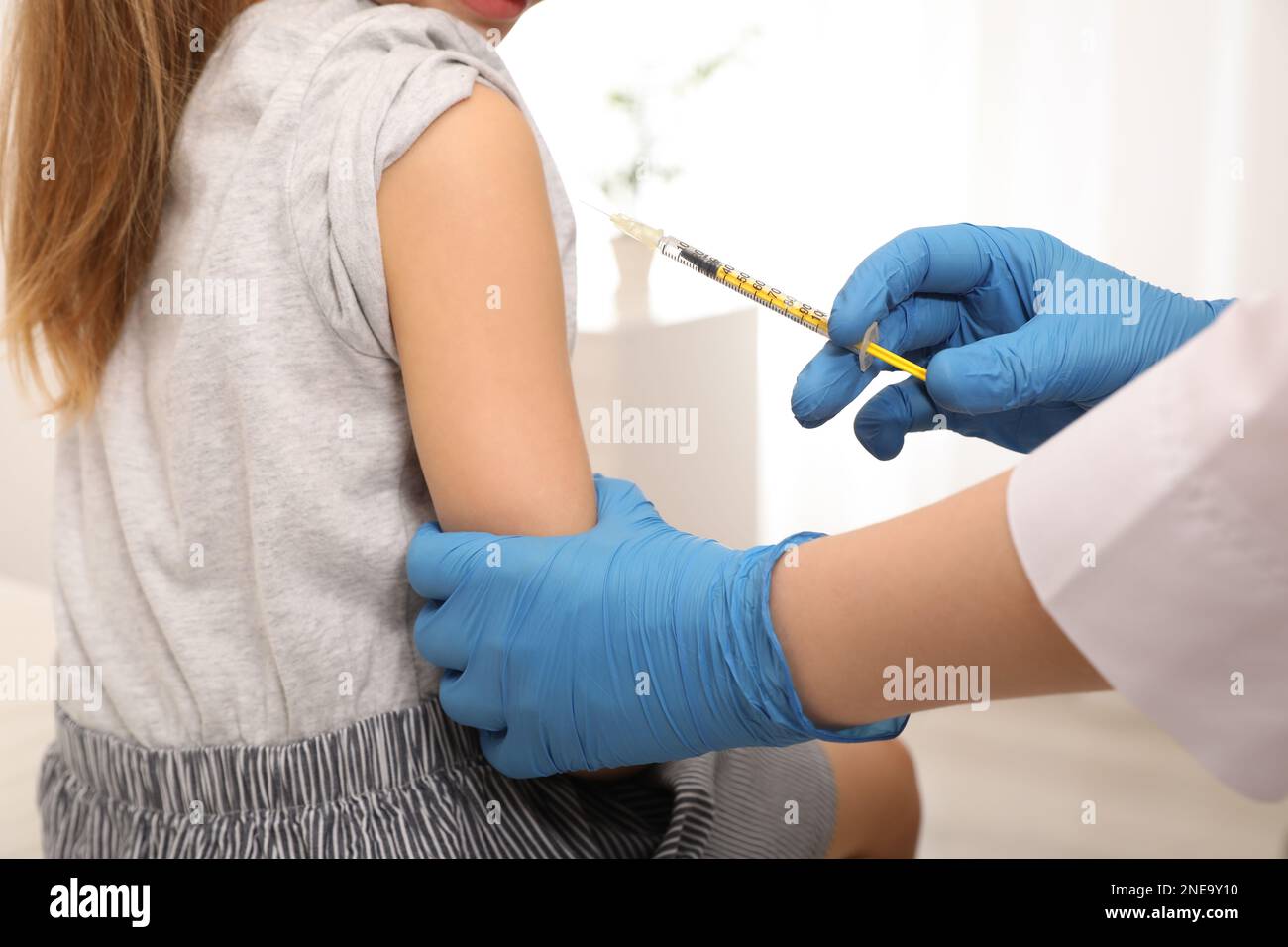 Doctor giving injection to little girl in hospital, closeup ...