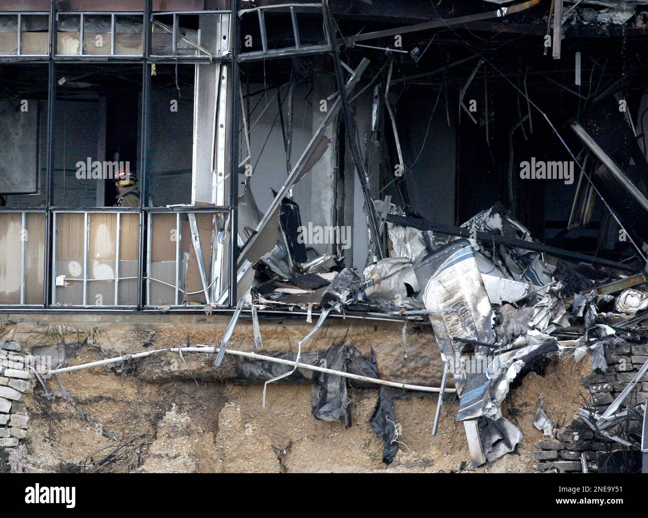 A firefighter is shown, left, walking around a ground level floor by ...