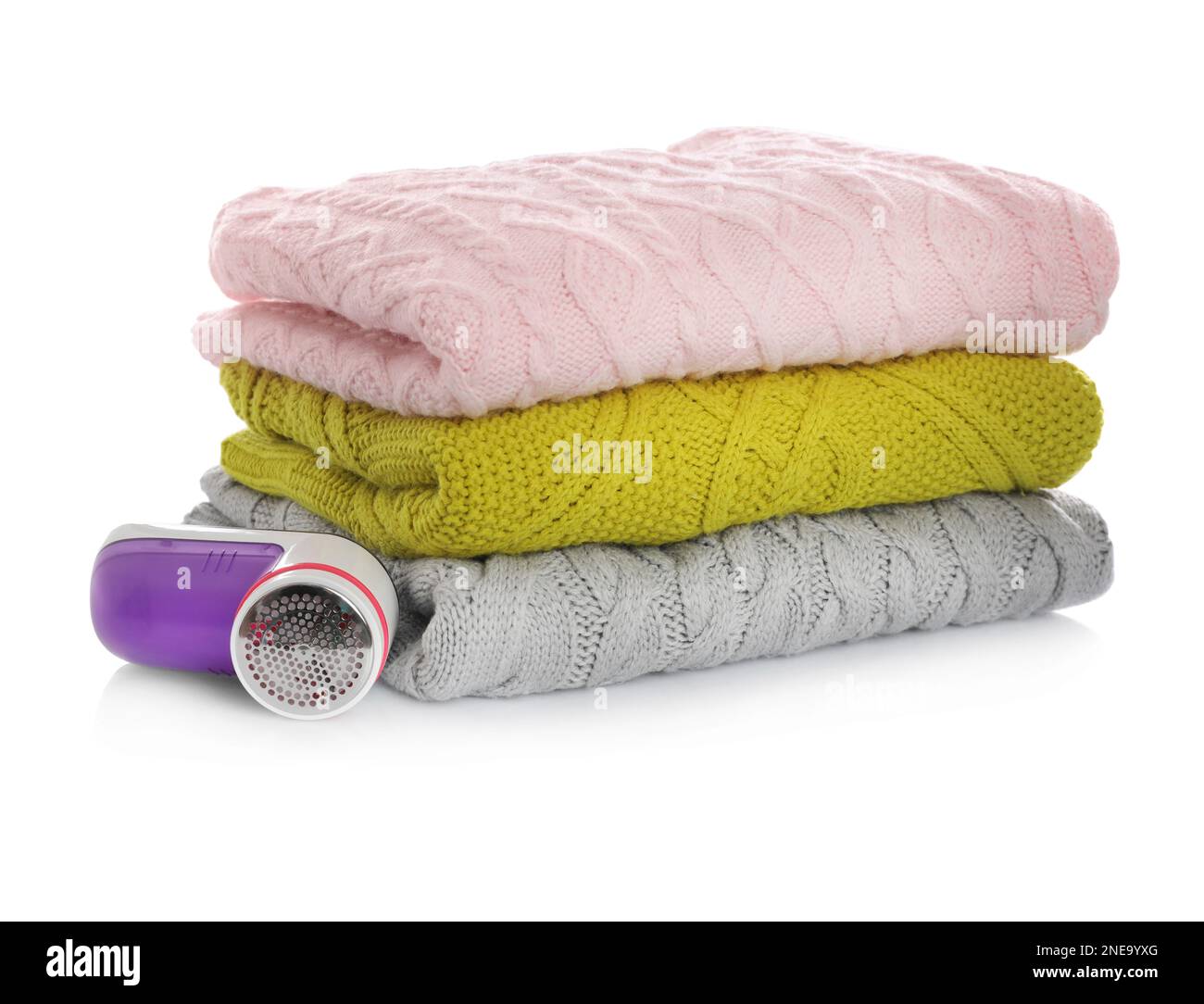 Modern fabric shaver and woolen clothes on white background Stock Photo ...