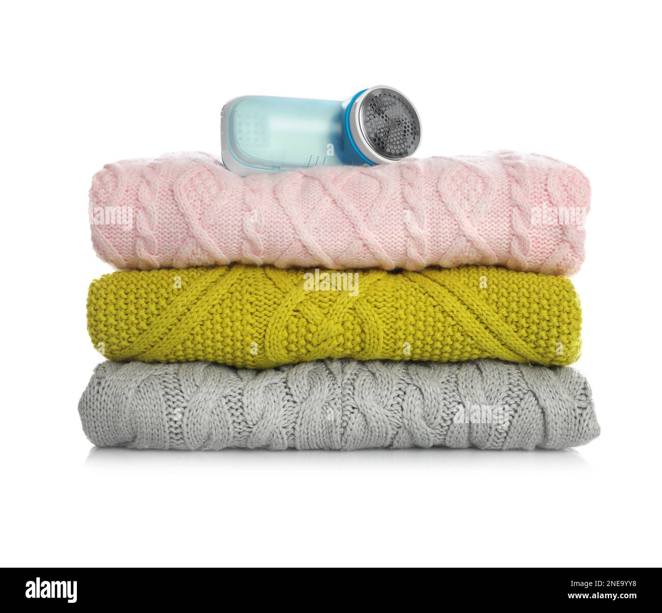 Modern fabric shaver and woolen clothes on white background Stock Photo ...