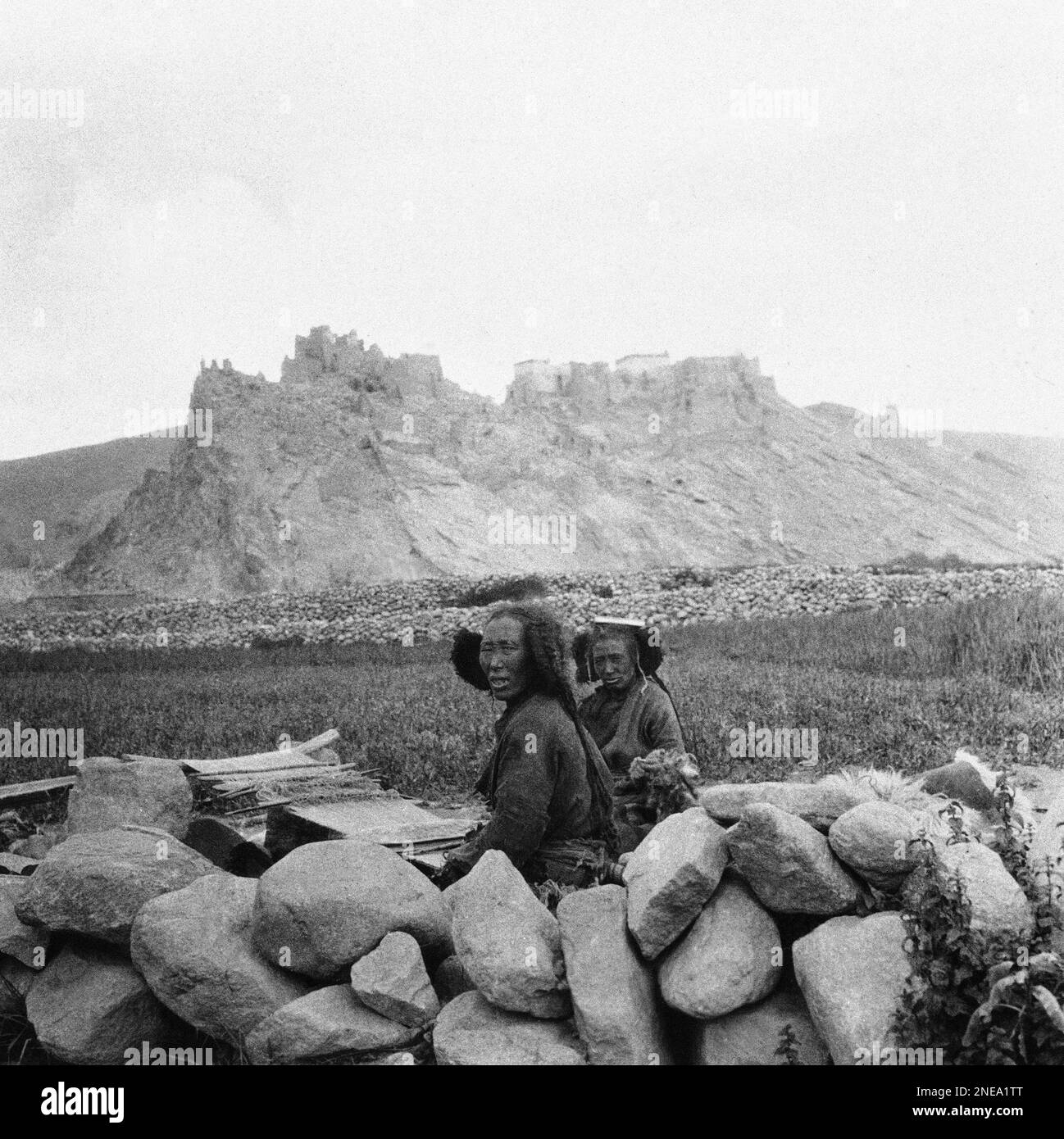 Tibetan weavers at work on a loom, May 18, 1932. The old fortress of ...