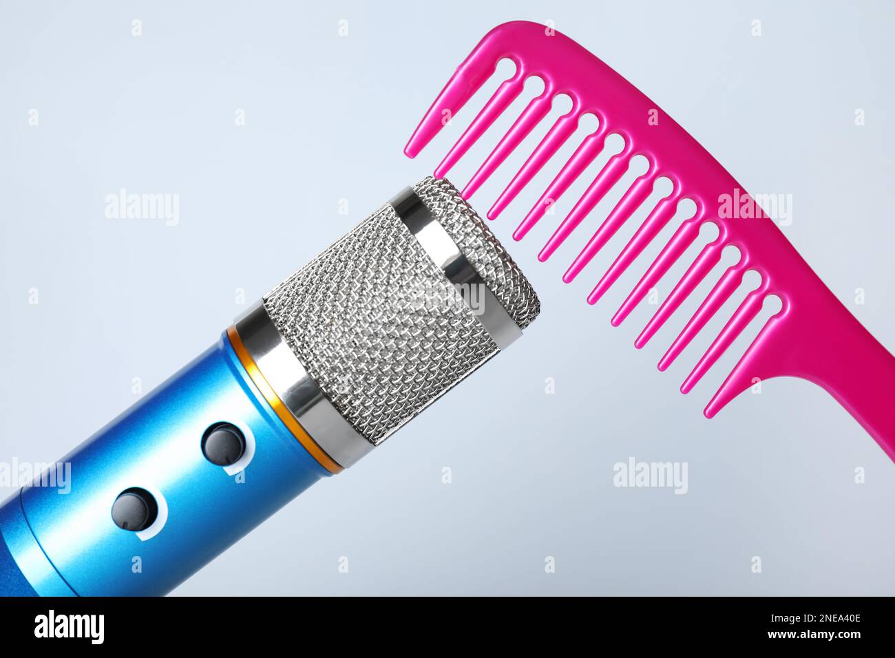 Making ASMR sounds with microphone and comb on grey background, closeup ...