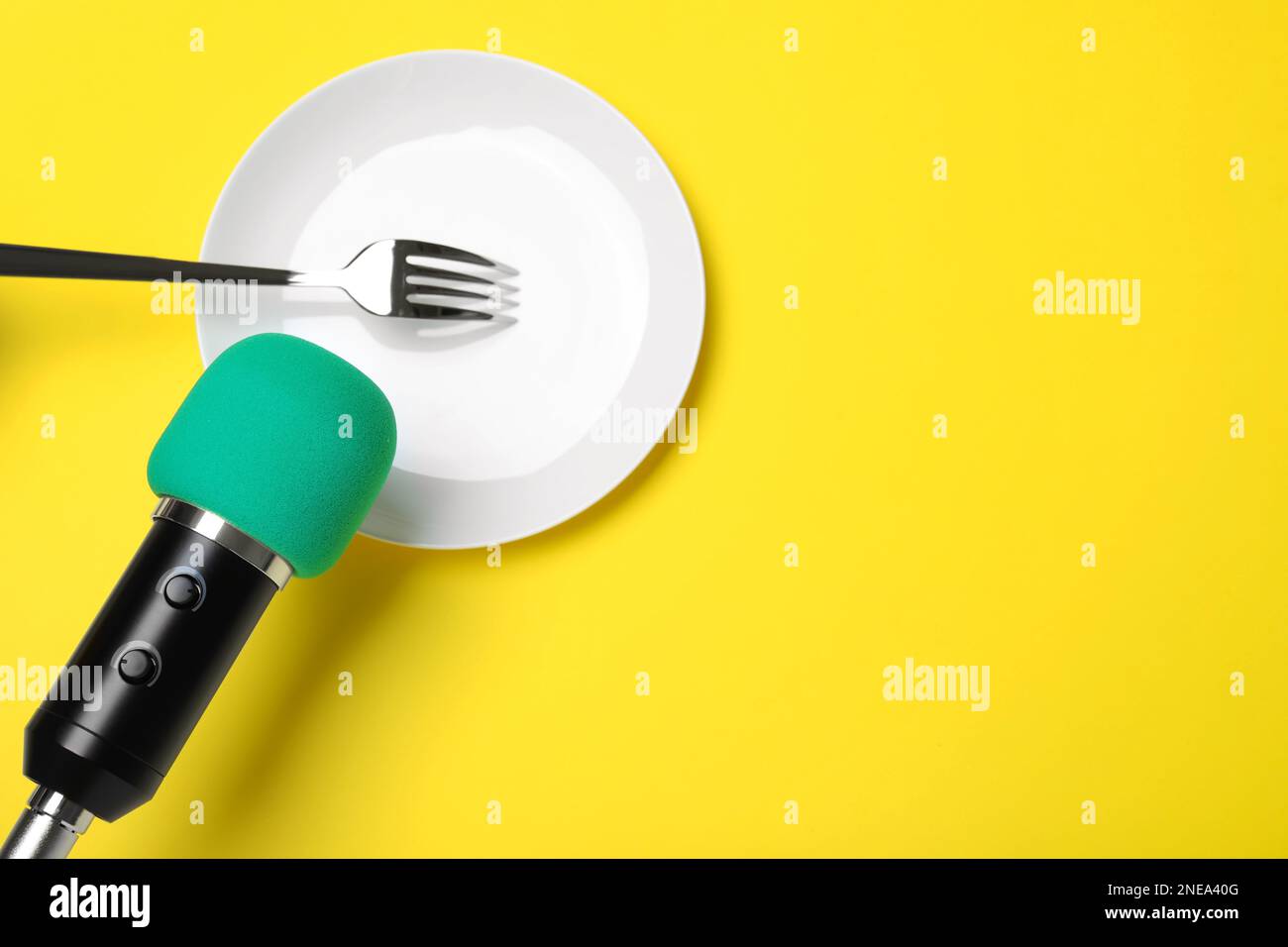 Making ASMR sounds with microphone, plate and fork on yellow background ...