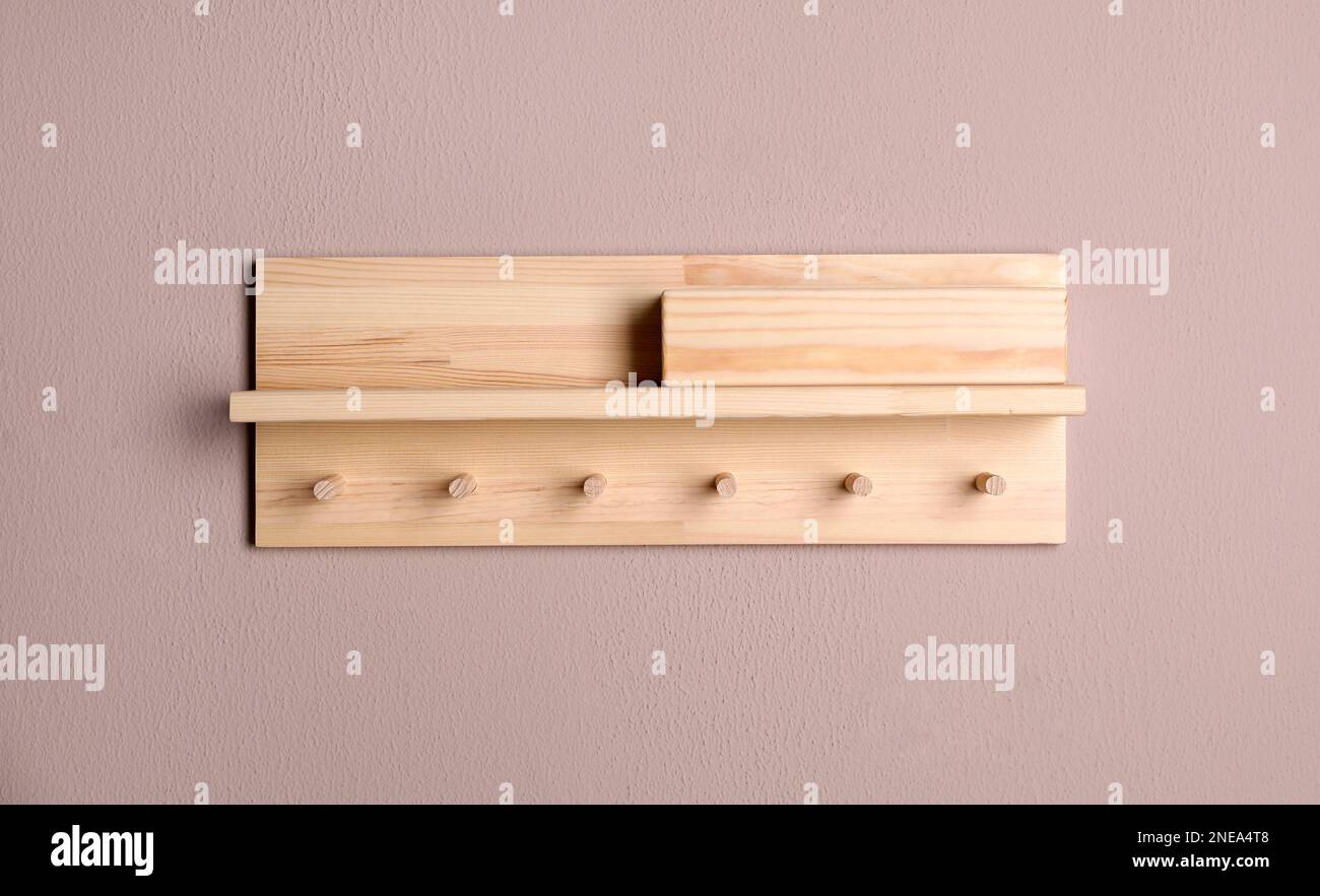 Wooden hanger for keys on color wall Stock Photo - Alamy
