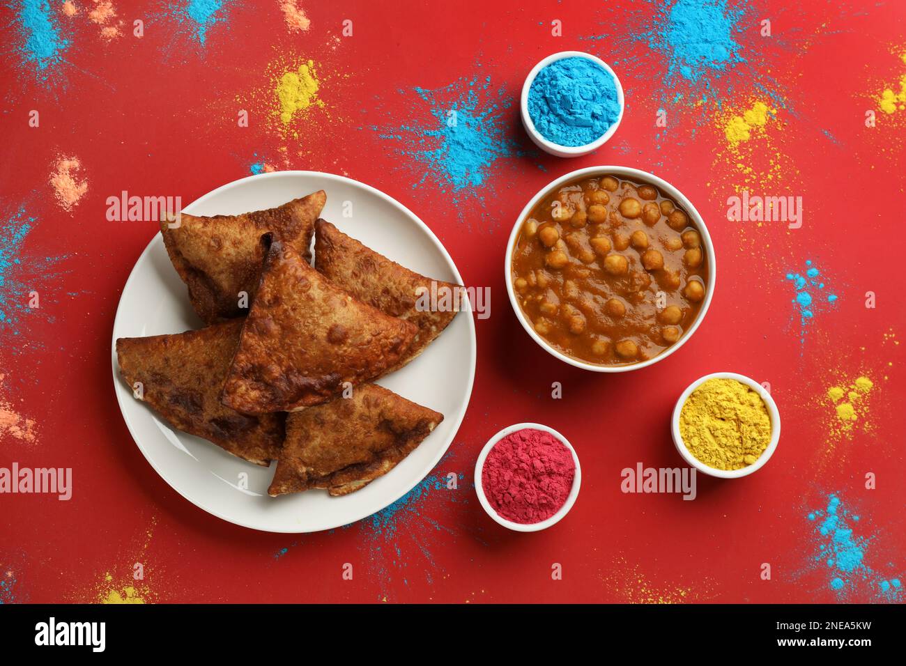 Traditional Indian food and color powder dyes on red background, flat ...