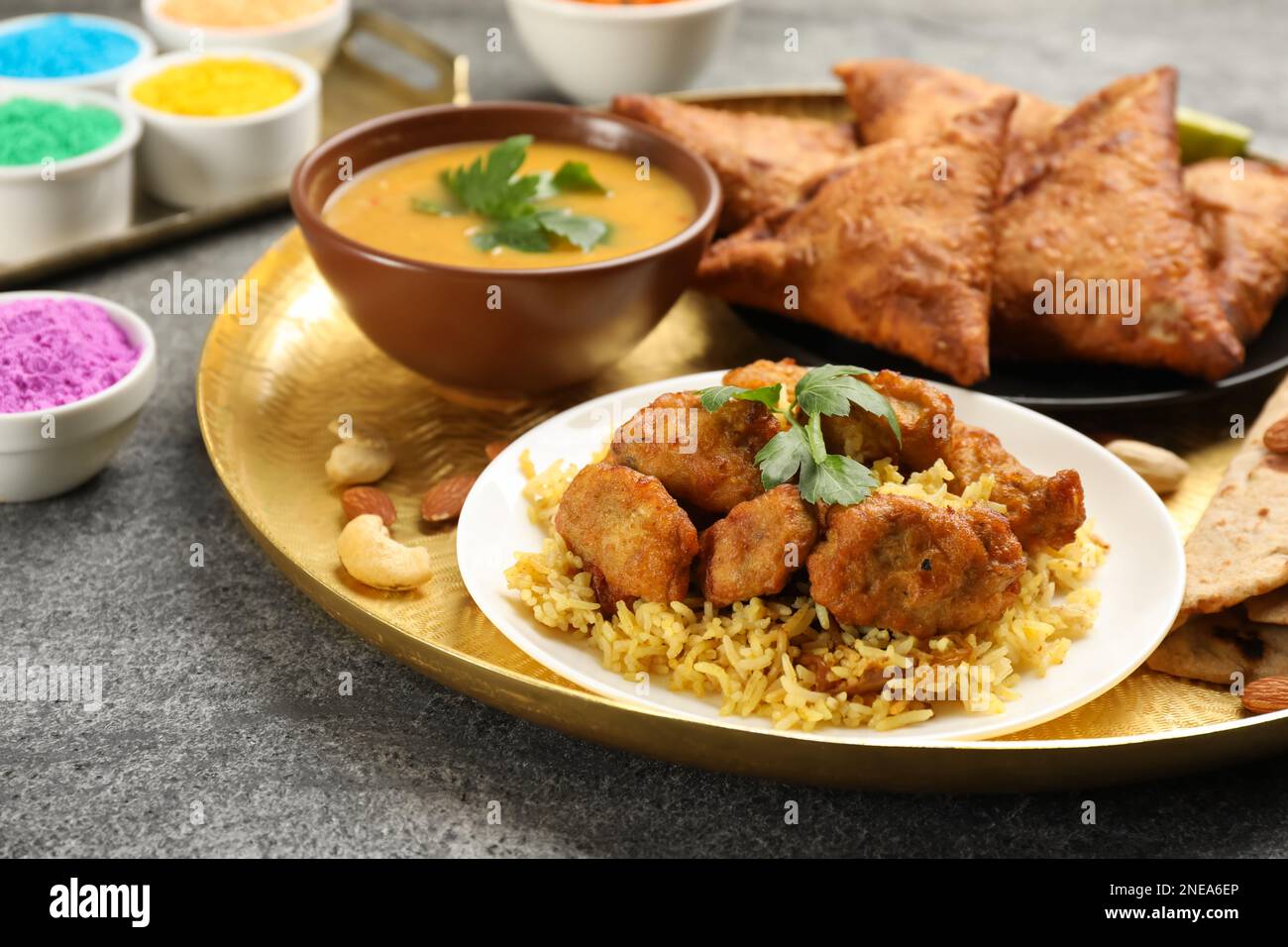 Traditional Indian food and color powders on grey table, closeup. Holi ...