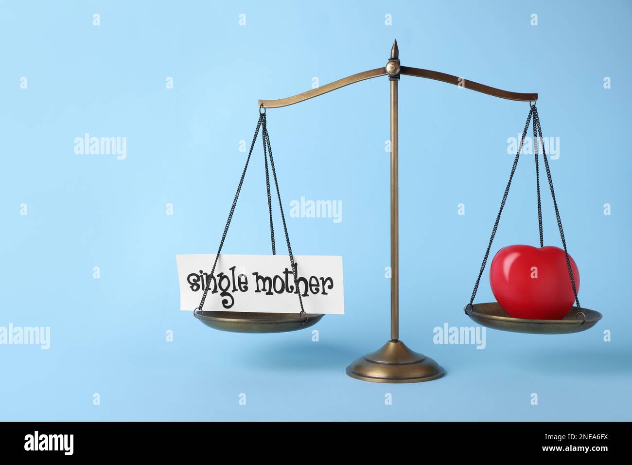 Being single mother concept. Scales with card and decorative heart on ...