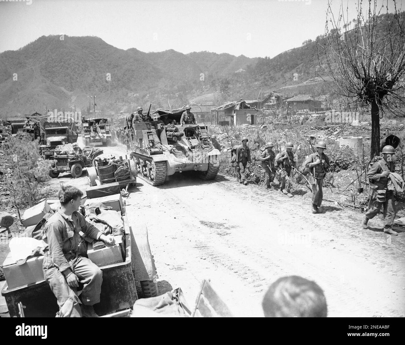 Trucks and troops of the U.S. second division move along on either side of road north of Inje in ...