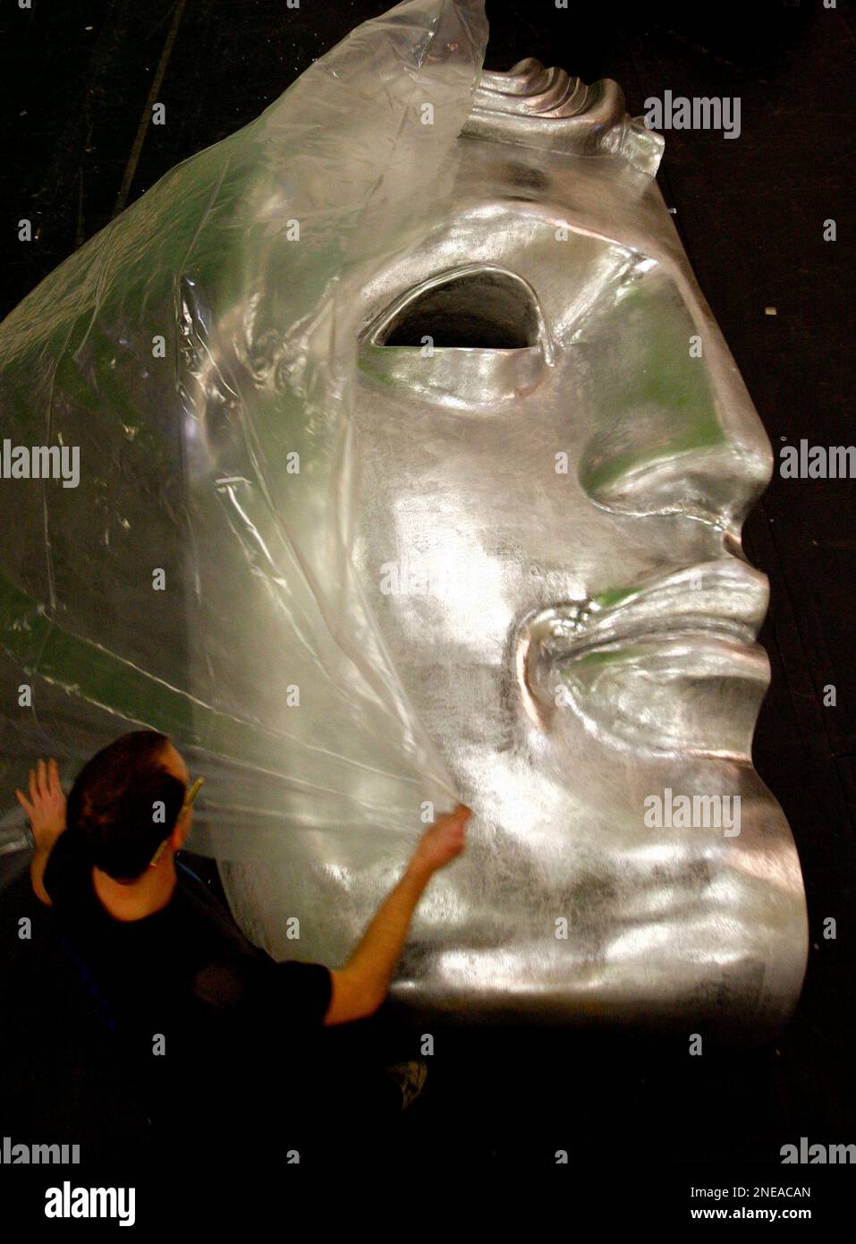 A giant mask is unveiled by a stage builder as preparations are made ...