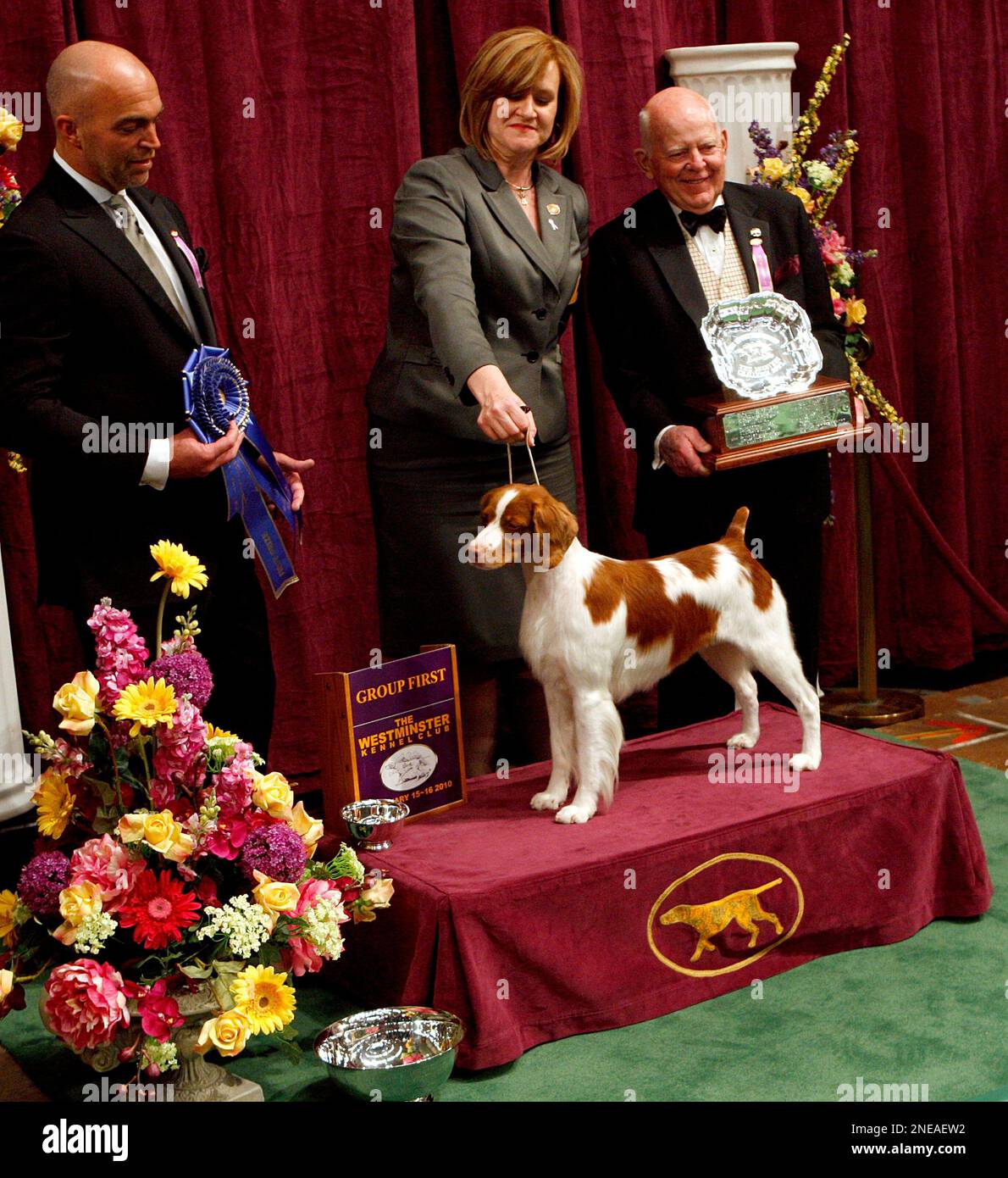 Tally, a Brittany, and her handler, Kellie Miller, accept the trophy ...