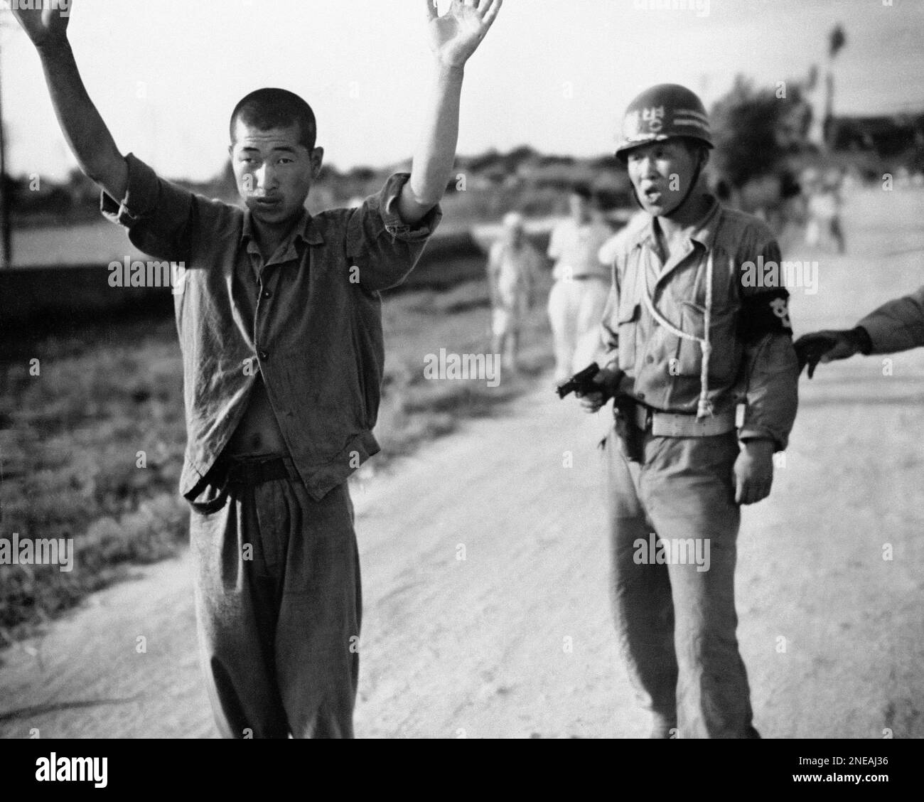 A South Korean military policeman marches a North Korean prisoner of ...